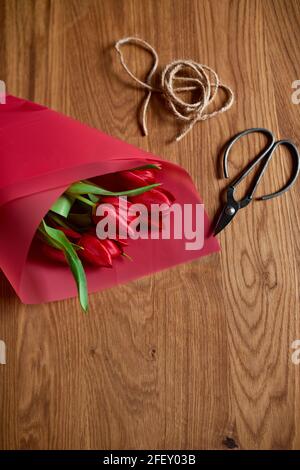 Floristic workplace with craft paper, twine Arranging pink tulips ...