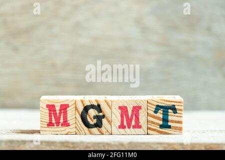 Wood letter in word mgmt (abbreviation of Management) on green grass ...