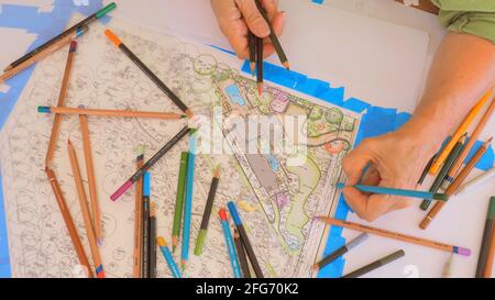 A left-handed artist uses pencils to hand-colour her landscape design ...