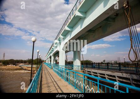Shardara river dam. Concrete bridge, gentry crane. Orange weights in ...