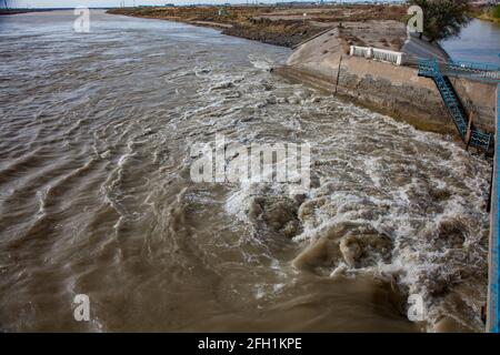 Dam of Shardara river. Concrete walls. turbulent river yellow water ...
