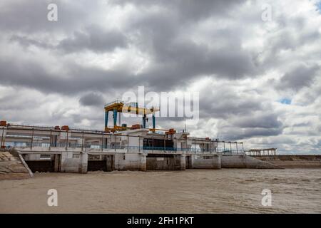 Shardara river dam near Kazaly city.Concrete slab on shore.Gantry crane ...