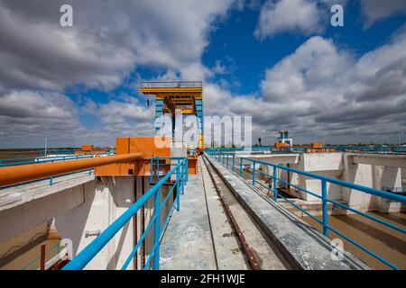 Shardara river dam. Concrete bridge, gentry crane. Orange weights in ...