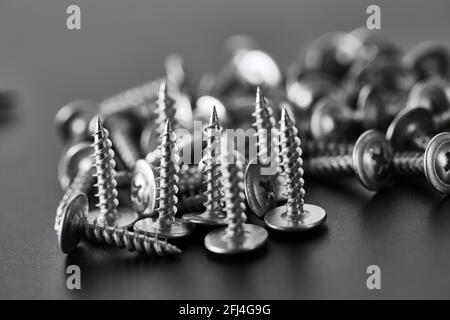 Stack of self-tapping screws, grey background, nobody. Professional ...