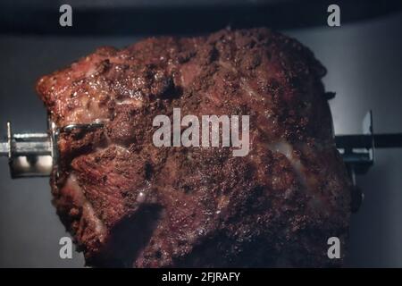 pork roast spinning and dripping fat on a rotisserie Stock Photo - Alamy