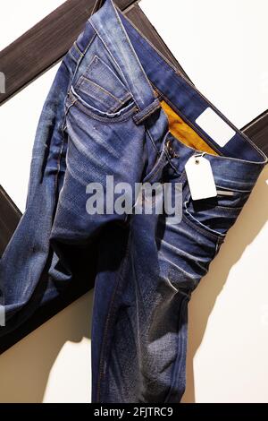 Rolled modern jeans on display in shop Stock Photo - Alamy
