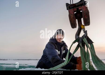 The slinger hooks the rope slings onto the hook of the truck crane ...