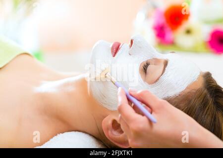 Wellness - woman receiving nurturing facial mask in spa for moist and ...