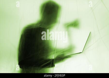 Anonymous Hacker commits computer crime Stock Photo - Alamy