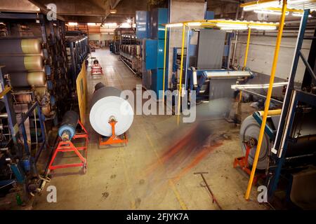 Denim getting steamed press in rolls in denim manufacturing industry ...