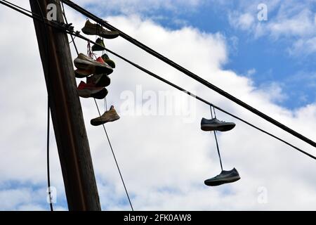 Running shoes dangle from the power lines outside of a running shoe ...