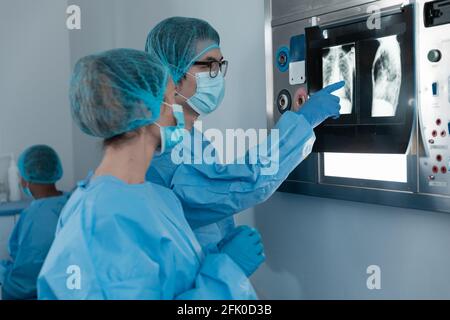 Diverse couple of male and female surgeons in operating theatre wearing ...