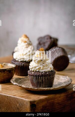 Chocolate muffins or cupcakes with whipped cream and berries, flat lay ...
