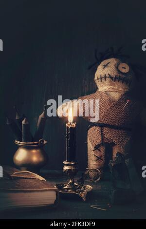 Voodoo doll on a wooden background with dramatic lighting. The concept ...