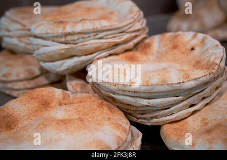 Homemade Kuboos, traditional pitta bread lie on a table of street ...