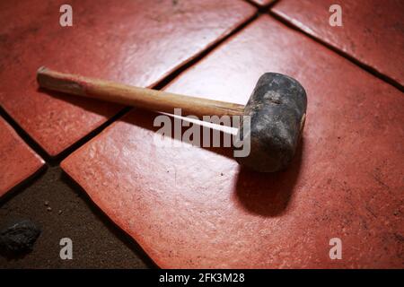 Wooden hammer laying on freshly laid ceramics tile Stock Photo - Alamy