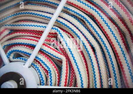 Abstact industrial background. Roll (spool) of red and orange rope on ...