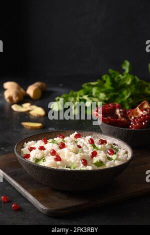 Curd Rice with pomegranate, cilantro, mustard seeds, ginger on a black ...