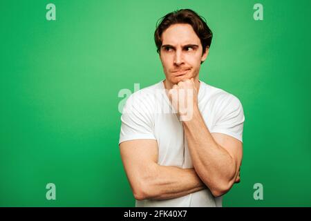 Portrait of handsome cheerful curious guy demonstrating copy space look ...