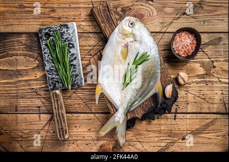 Raw fish Sunfish or pompano on a wooden board. wooden background. Top ...