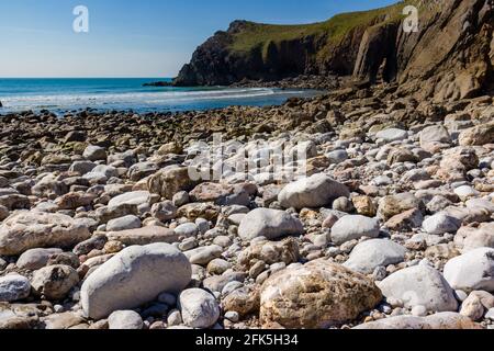 Scenic beach with cliff and rocks surrounded with vibrant transparent ...