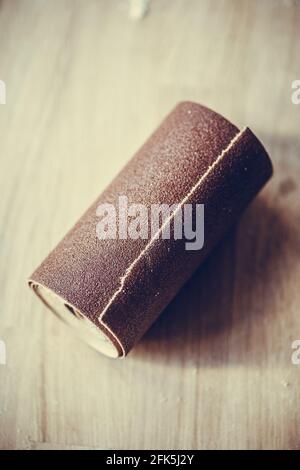 Close up shot of a sandpaper roll on a wooden table Stock Photo - Alamy