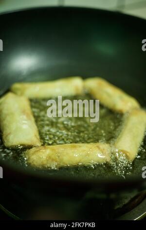 Vertical shot of spring rolls frying in a pan Stock Photo - Alamy