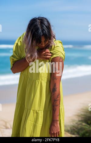 Pretty woman with tattoo on her arm holding her cute little dog over ...