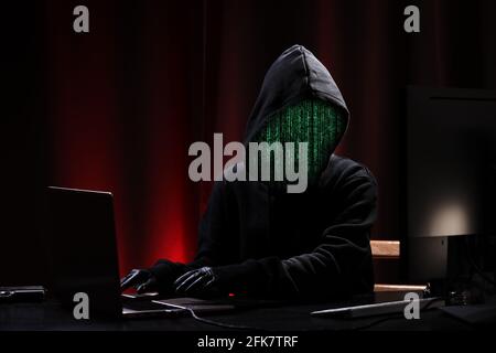 International hacker in black pullover and black mask trying to hack ...