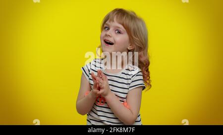 Sneaky playful blonde child girl conspiring scheming, thinking over ...