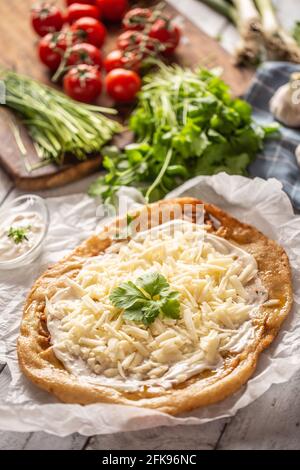 Traditional Hungarian lángos served with sour cream (tejfol) and ...