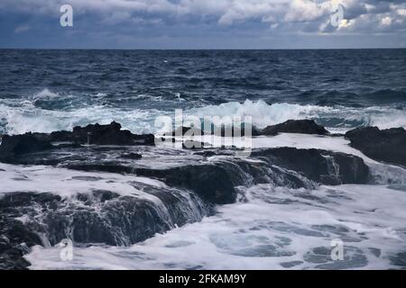 Wave splashing over and running into rock formation in the Atlantic ...