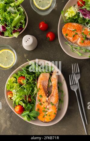 Delicious roasted trout fillet with lettuce salad, tomatoes and creamy ...
