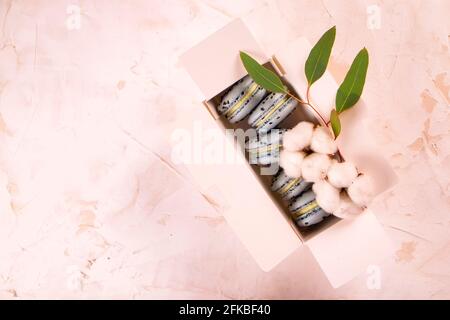 Beautiful composition of blue and pink macaroons with shadows on a blue ...