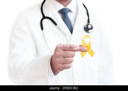 yellow ribbon-childhood cancer awareness symbol on the wooden ...