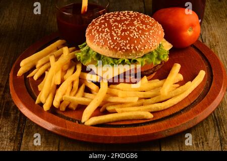 Cheeseburger and chips on a wooden plate Stock Photo - Alamy