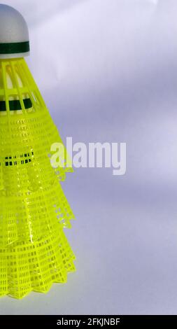 white badminton shuttlecocks and bright yellow tennis balls on white ...