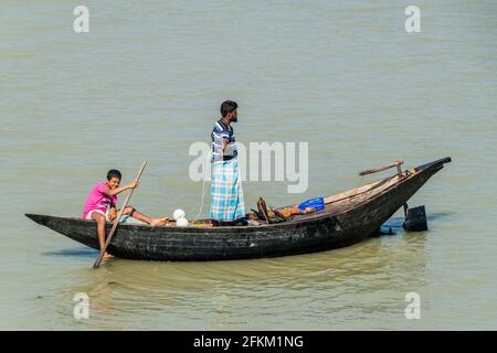KATCHA RIVER, BANGLADESH - NOVEMBER 19, 2016: Fishermen on a small boat ...