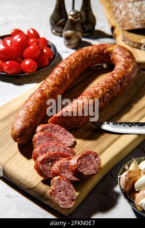 German Smoked sausage on a wooden rustic board with thyme. Dark wooden ...