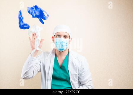 The doctor plays and throws up his gloves. On a light background. High ...