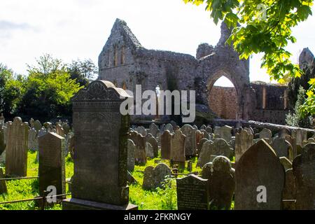 A backlit view of the ruins of the historic Greyabbey Monastery that ...
