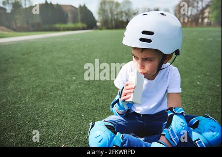 Boy in a Protective Helmet Drinking from a Cup: The Essence of ...