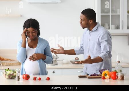 Sad pregnant woman fighting with her husband sitting on a sofa at home ...