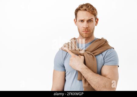 Disappointed guy with red hair showing thumbs-down, frowning and ...