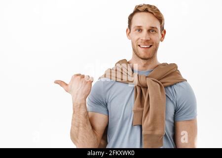 Attractive excited young brunette man wearing plaid shirt standing ...