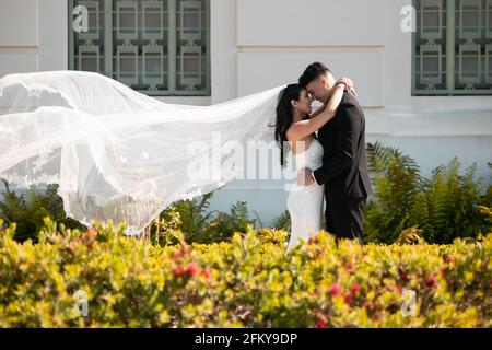 Couple, wedding and kissing with vail for love, compassion or affection ...