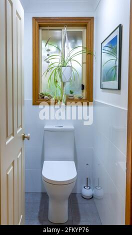 Toilet in a narrow white bathroom Stock Photo - Alamy
