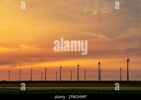 Gorgeous shot of a field covered with wind turbines and magical orange ...