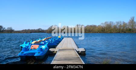 A line of pedaloes tied up to the jetty at Dinton Pastures Stock Photo ...