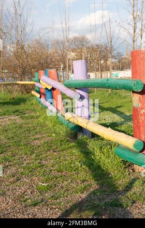 Rustic hedge made of logs of different vibrant colors Stock Photo - Alamy